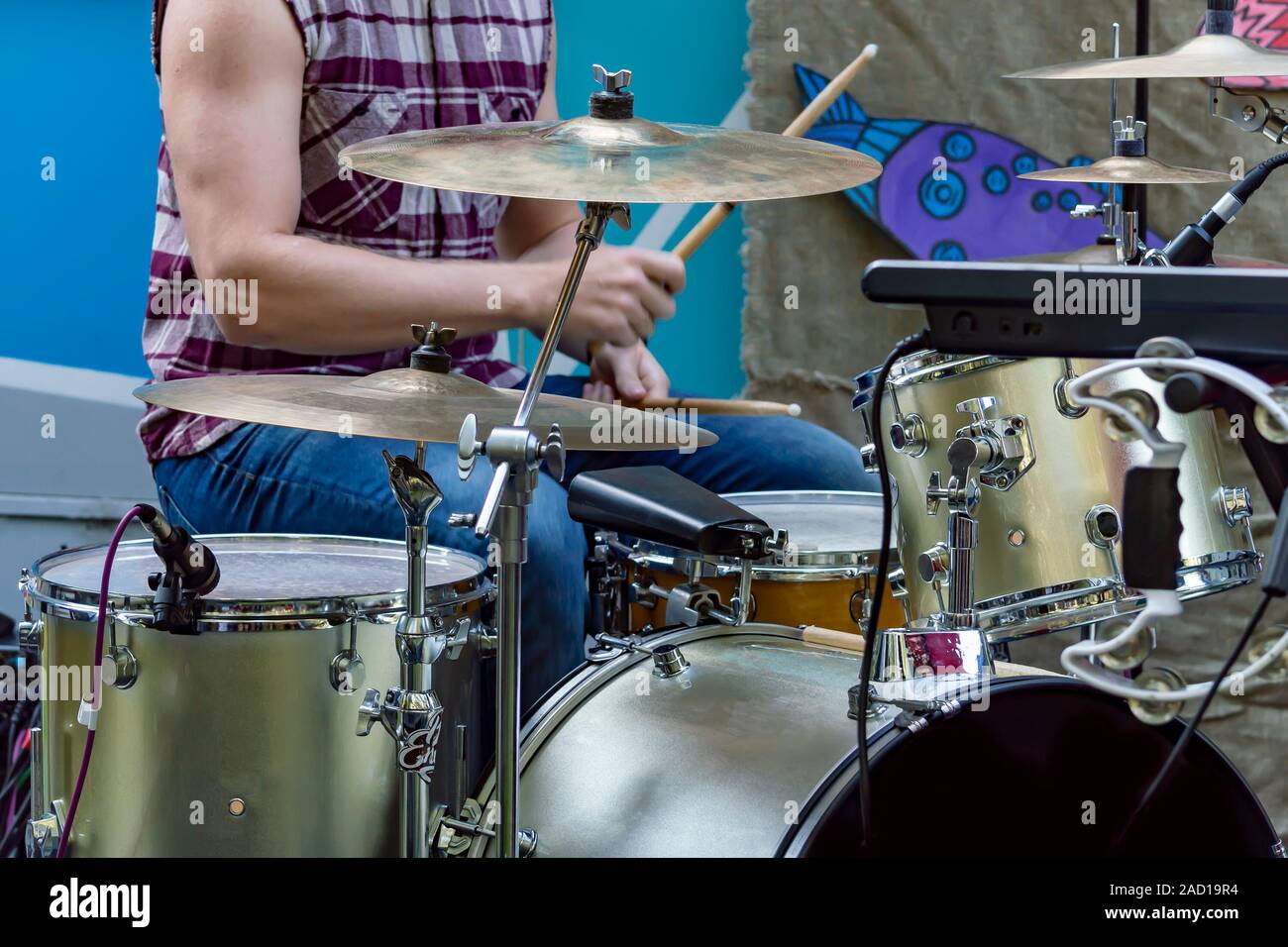 Drummer plays drum kit in open. Side view Stock Photo - Alamy