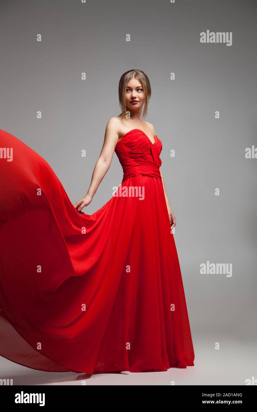 Beautiful model in red dress with flying skirt Stock Photo - Alamy