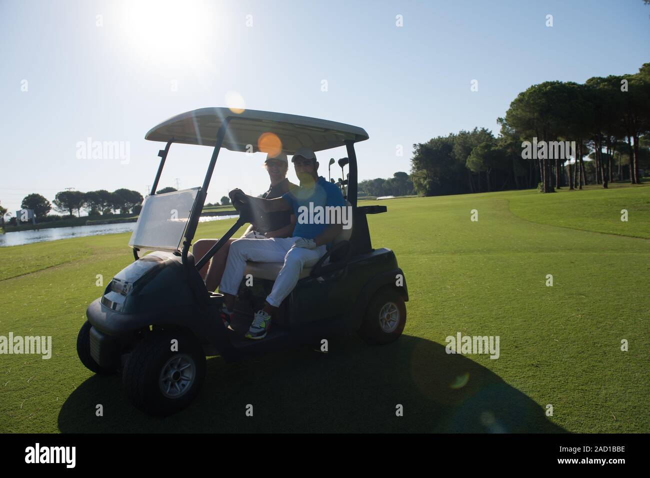 golf players driving cart at course Stock Photo - Alamy