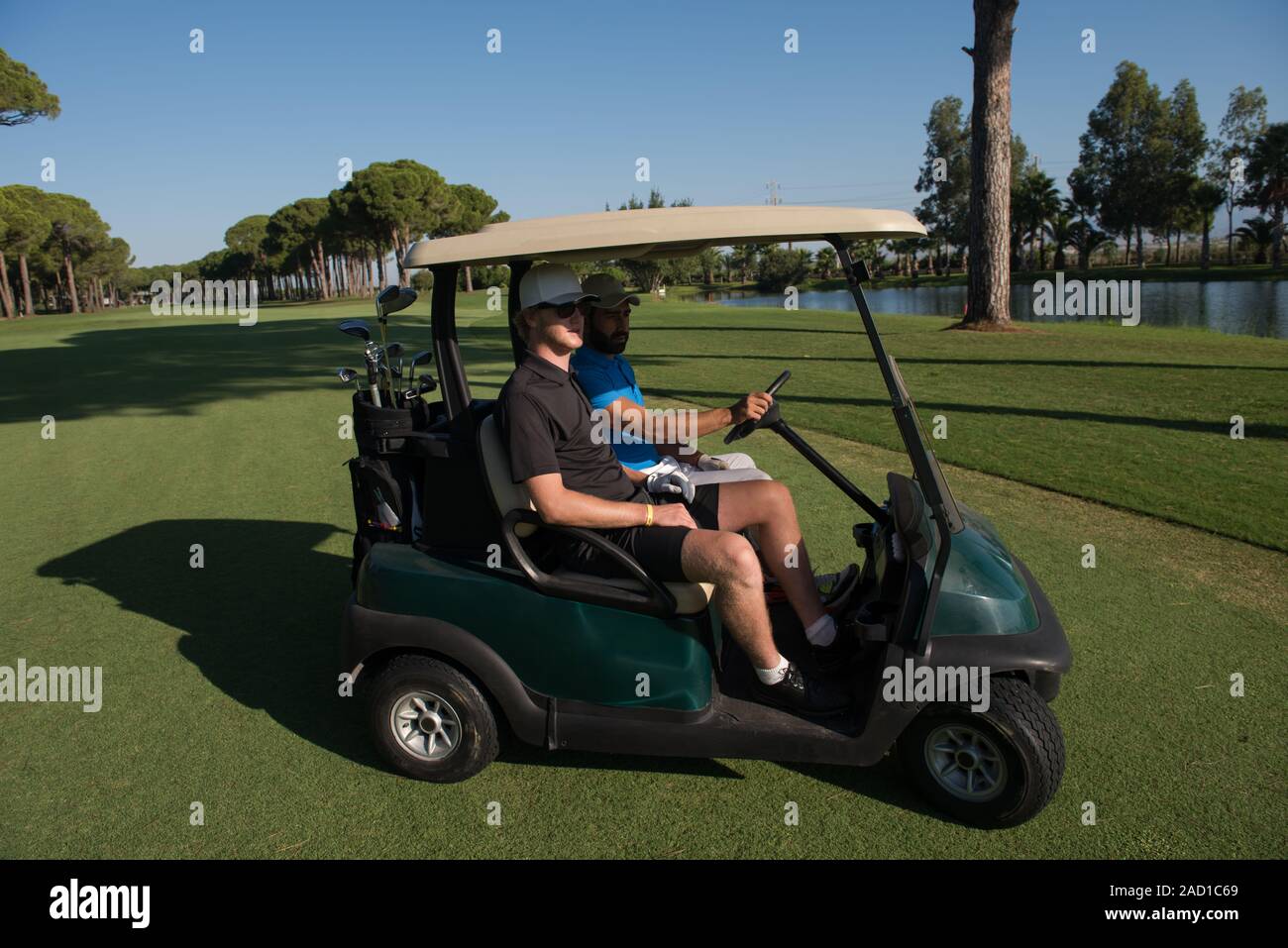 golf players driving cart at course Stock Photo - Alamy