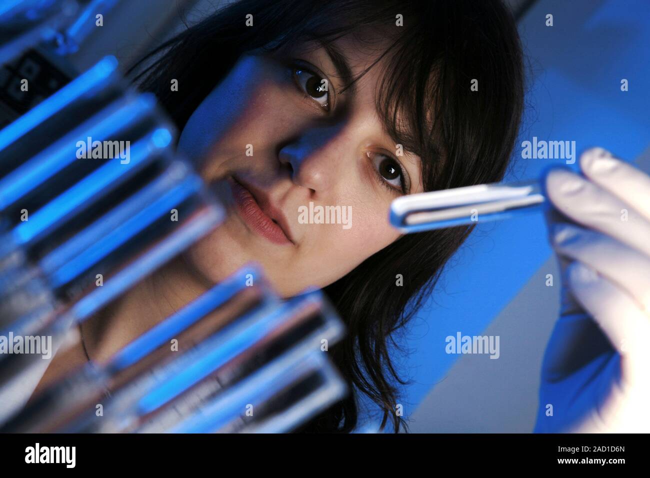 Molecular therapy research. Technician holding a test tube in a ...