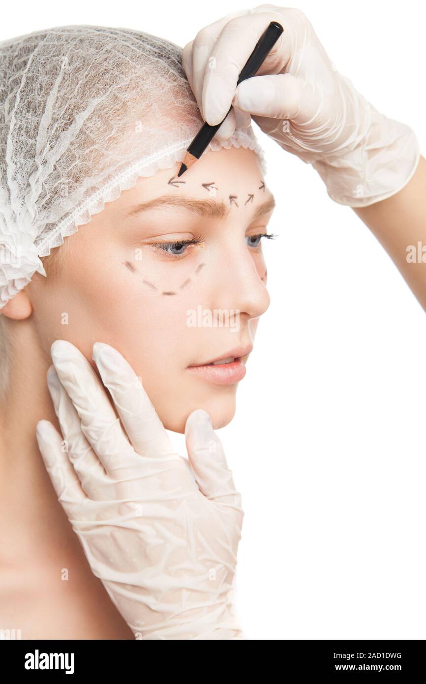Plastic surgeon drawing outlines on womans face Stock Photo - Alamy