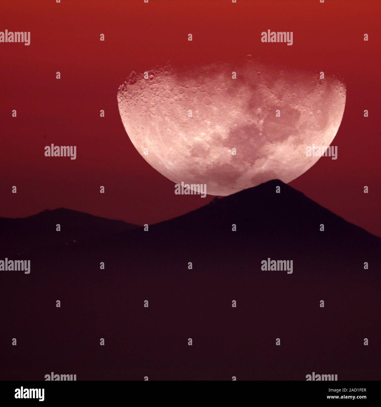 Moon over mountains. View of a half moon setting behind a mountaintop ...