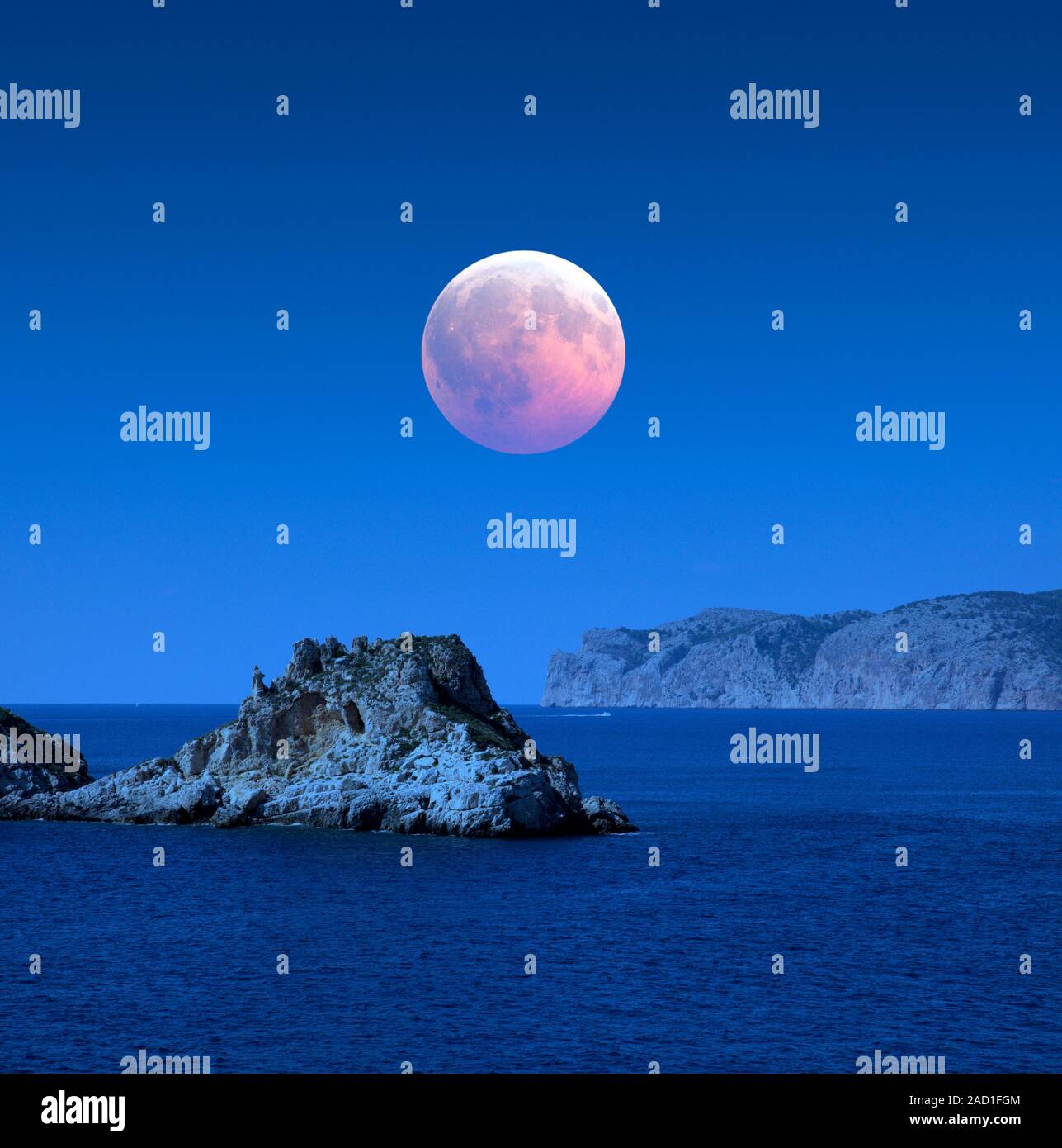 Lunar eclipse. View of the Moon over coastal rock formations during a ...
