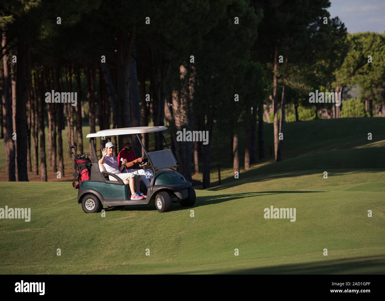 couple in buggy on golf course Stock Photo - Alamy