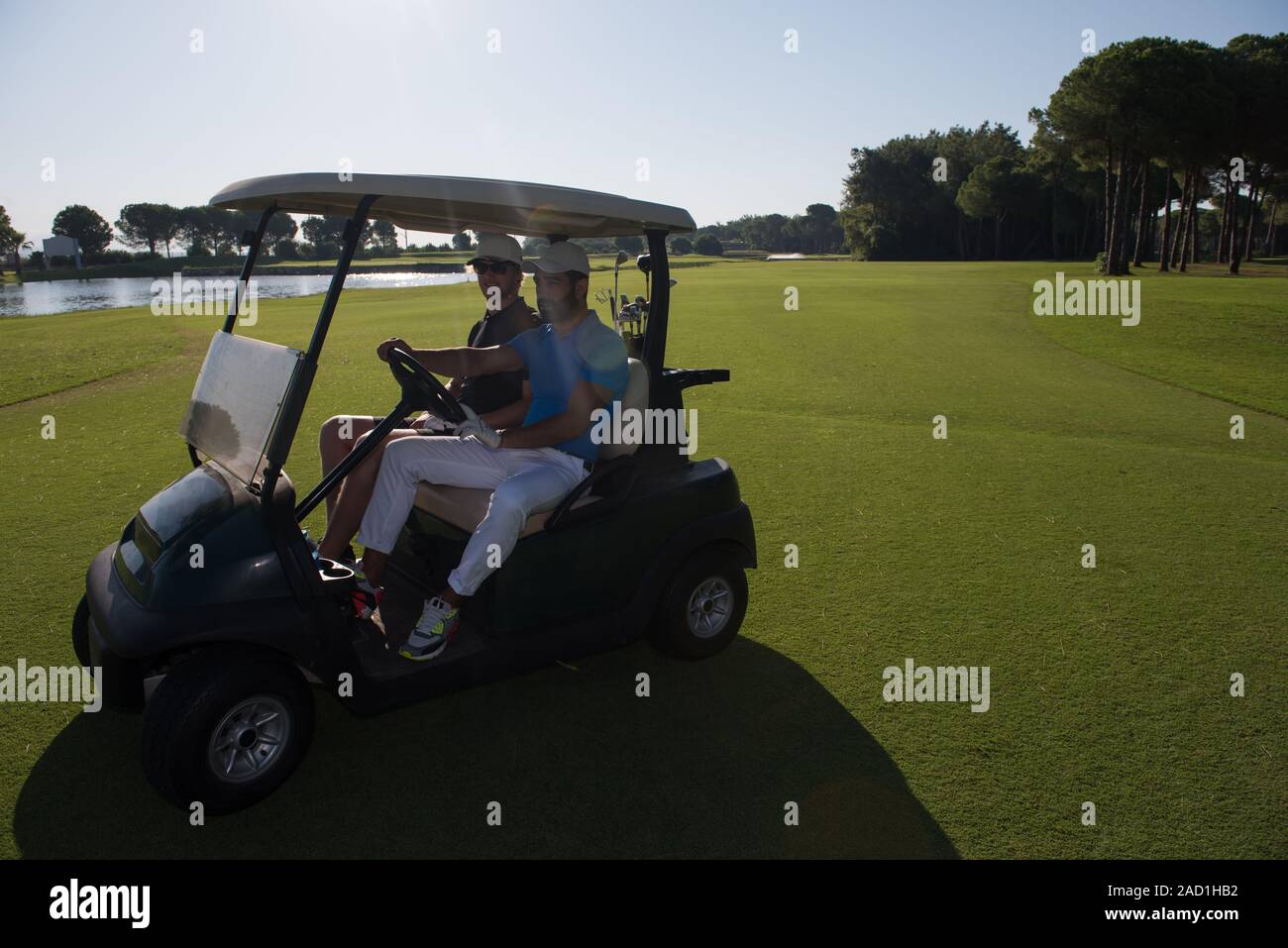 golf players driving cart at course Stock Photo - Alamy