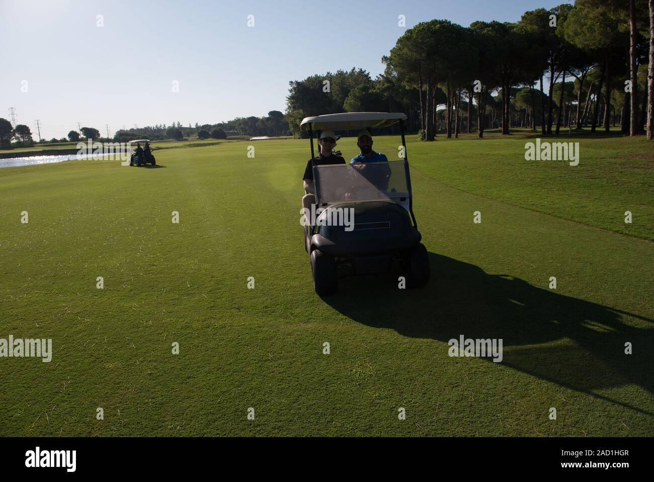 golf players driving cart at course Stock Photo - Alamy