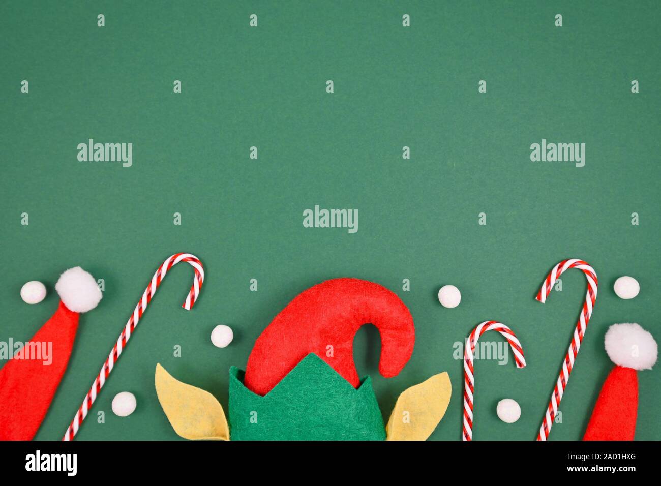 Seasonal flat lay with Christmas elf hat and ears, candy canes, red ...