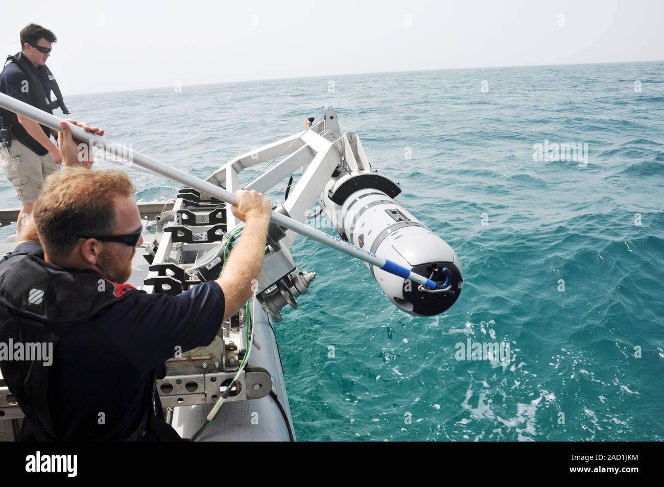 US Navy underwater mine clearance drone. US Navy sailors lowering an ...
