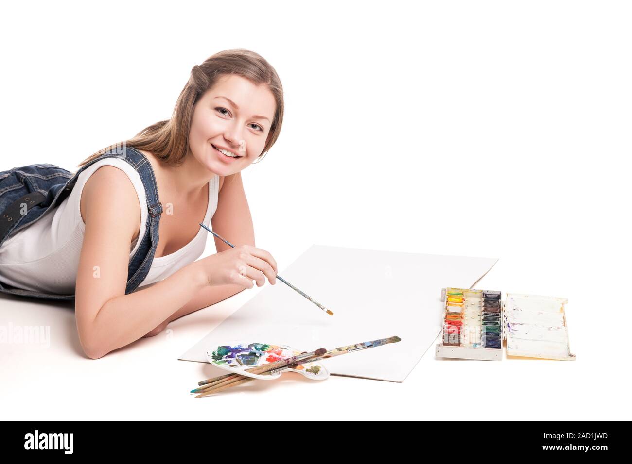 Young woman happily lies on the floor drawing in her note pad Stock ...