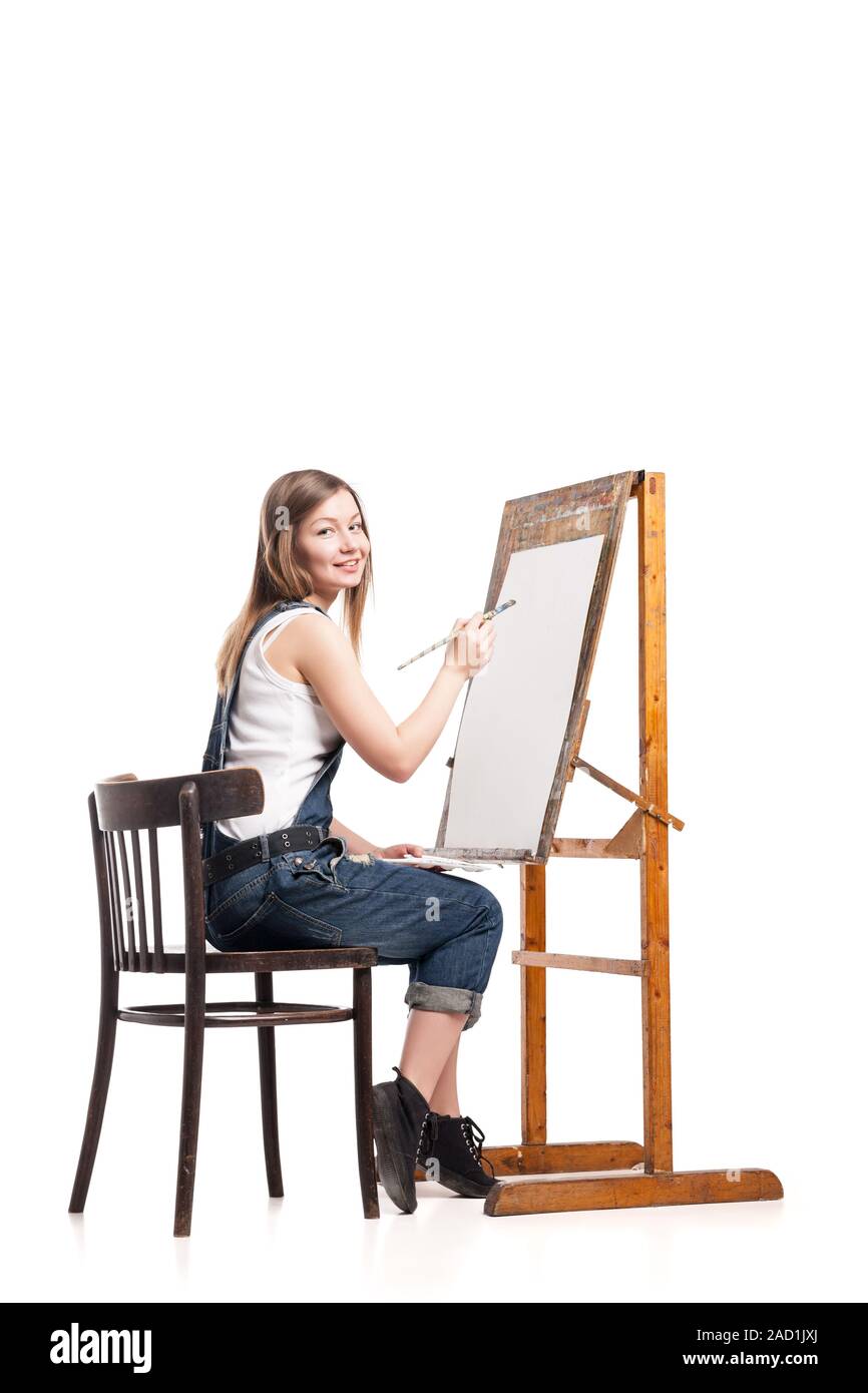 Young smiling woman painter with paintbrush standing at easel Stock ...