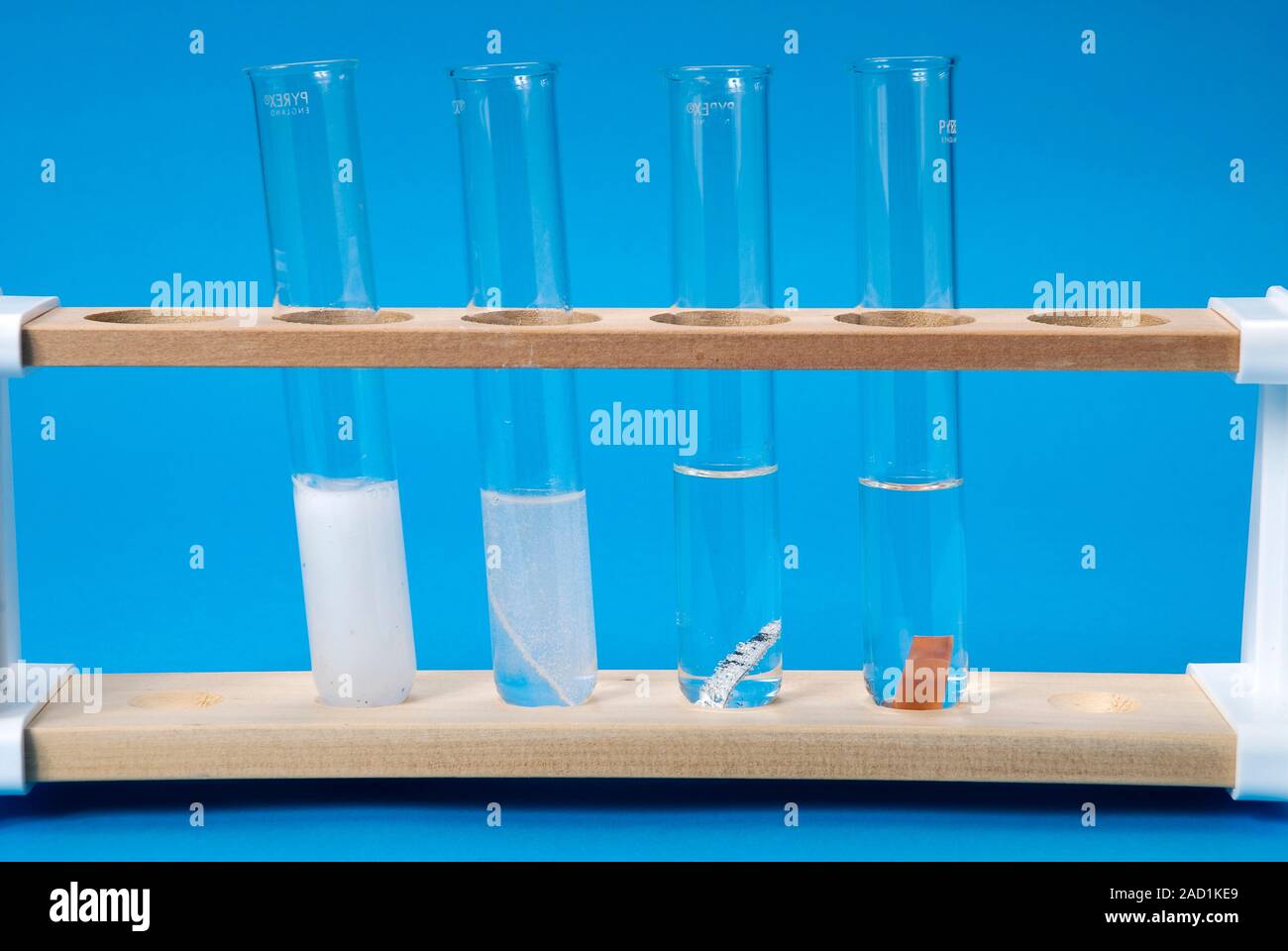 Metals in acid. Four test tubes containing different metals in ...