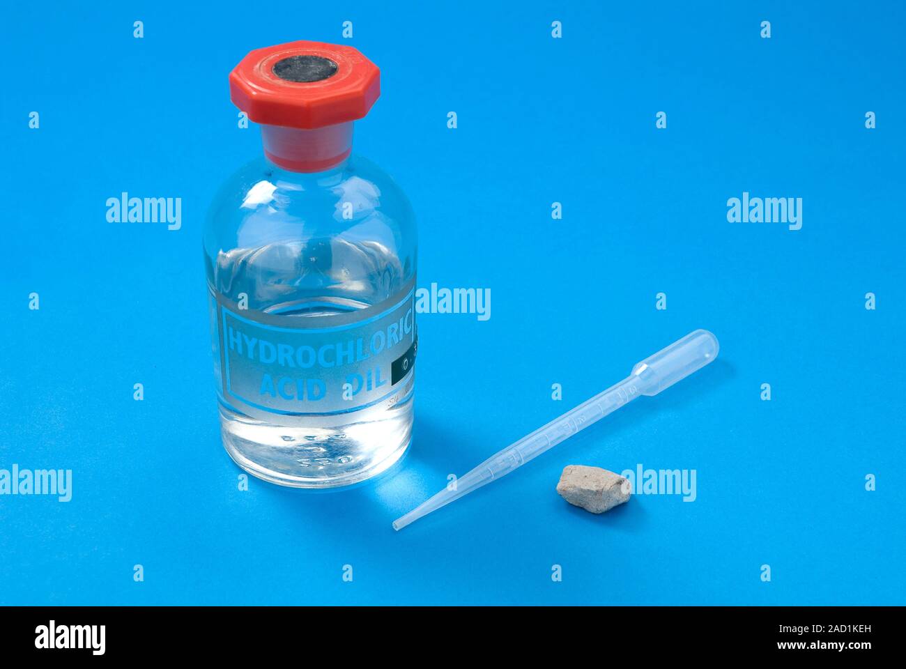 Limestone and acid. Piece of limestone with a pipette and a bottle of ...