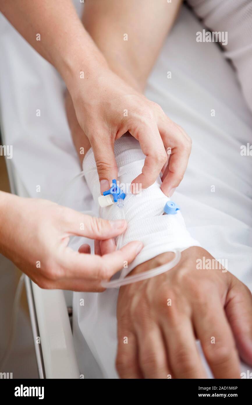 Chemotherapy treatment. Close-up of a nurse checking a cannula in the ...