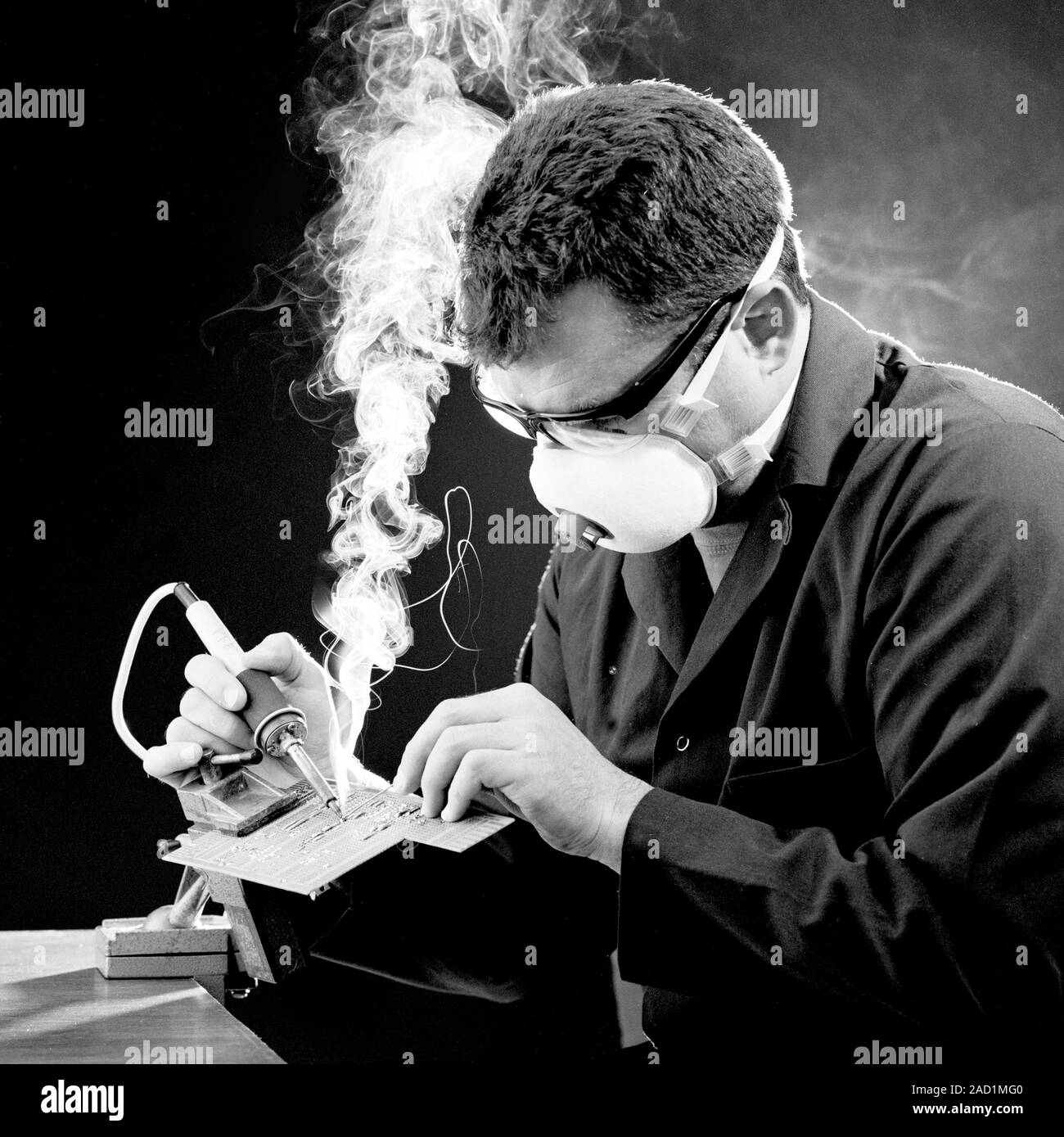 Protection from soldering fumes. Worker wearing a breathing apparatus ...