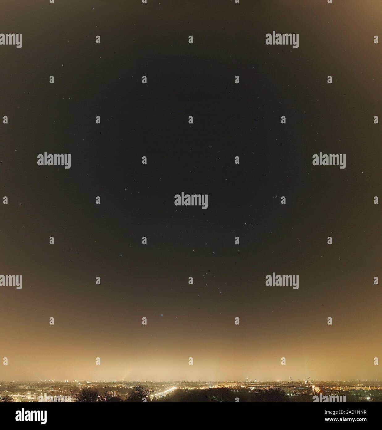 Winter stars and light pollution. View of the night sky over a city ...