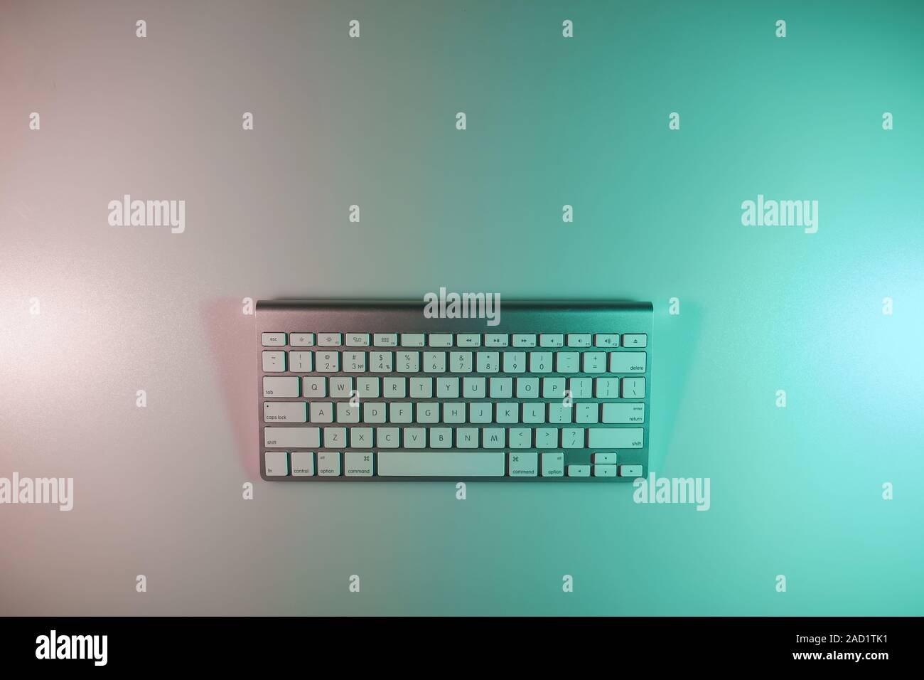 Beautiful modern silver keyboard in the color light on a table and ...
