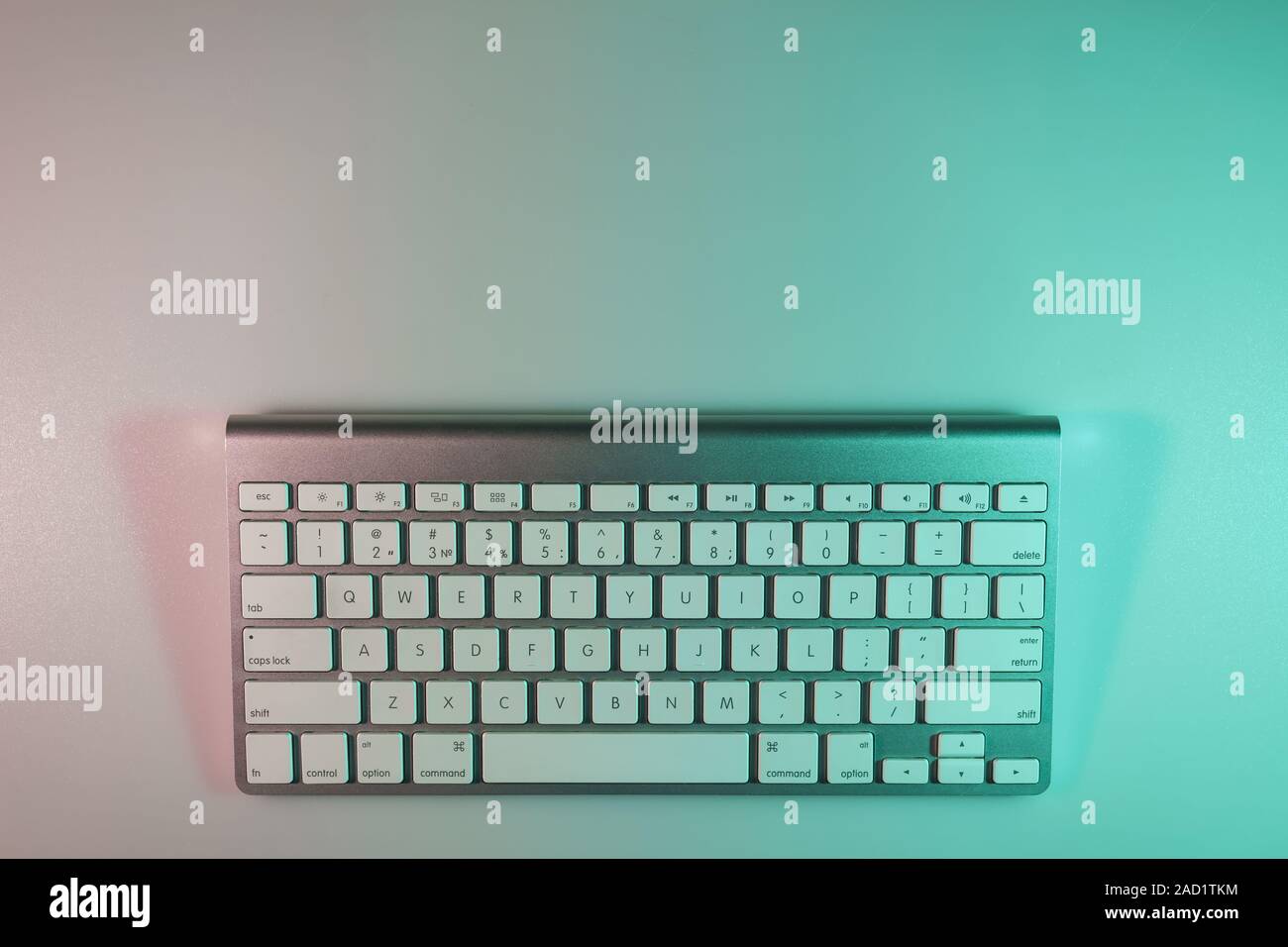 Beautiful modern silver keyboard in the color light on a table and ...