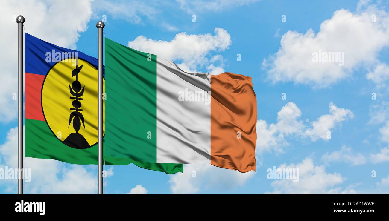 New Caledonia and Ireland flag waving in the wind against white cloudy ...