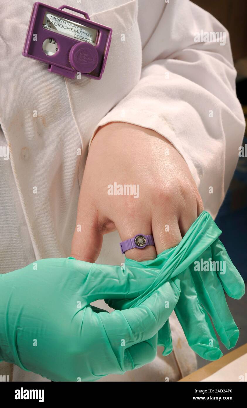 Laboratory dosimeter use. Close-up of a researcher wearing finger and ...