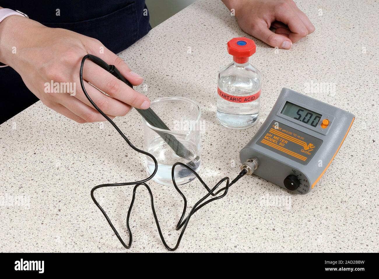 Measuring pH. Student using a digital pH meter to measure the acidity of a tartaric acid ...