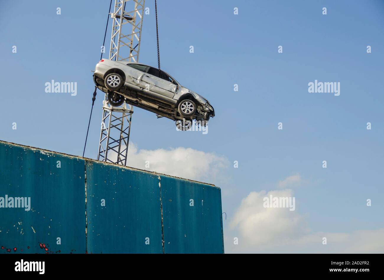 Crash damaged car hanging from crane at breakers yard. Photographed in ...