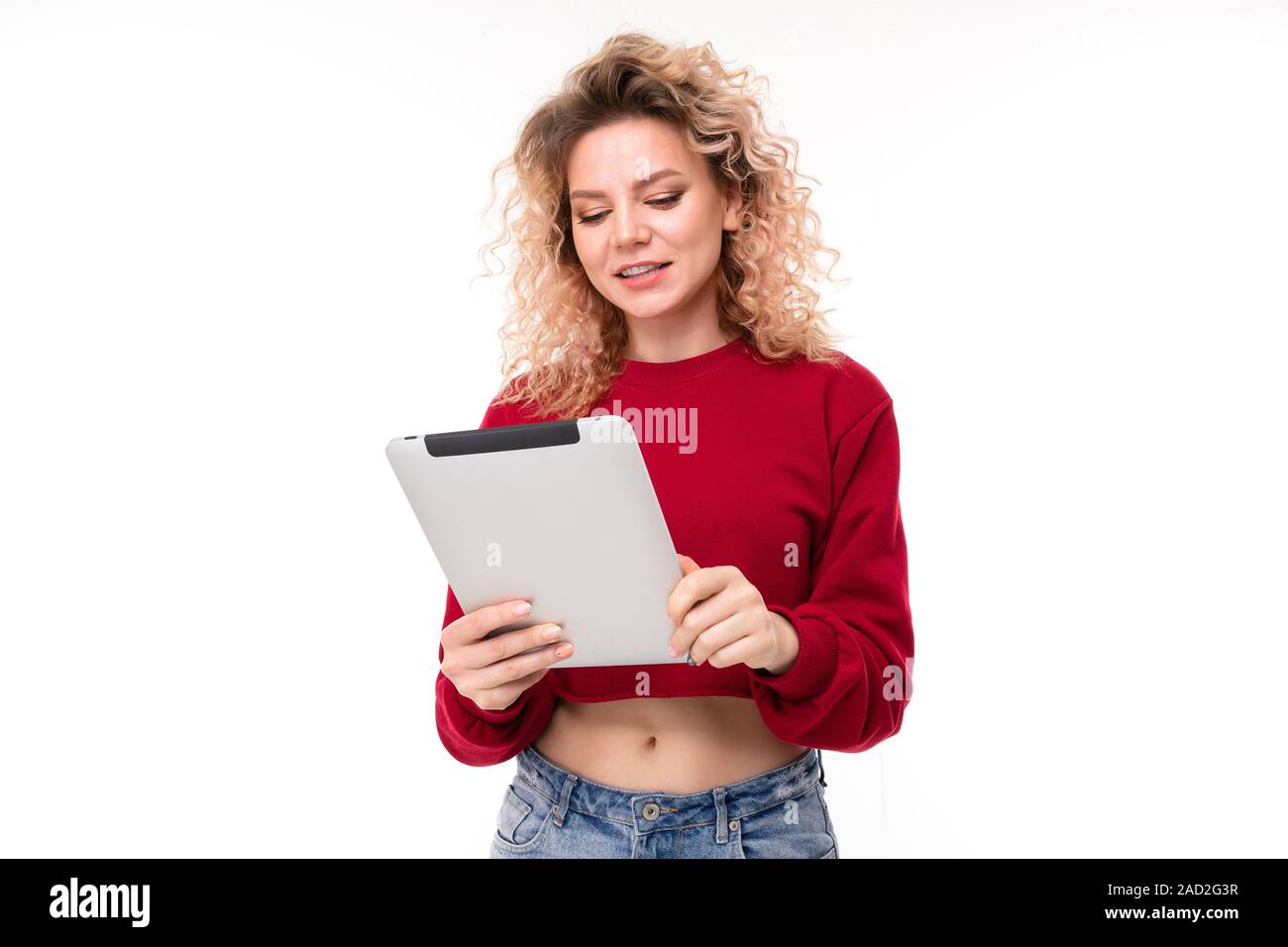European girl reads messages on a tablet on a white background Stock ...