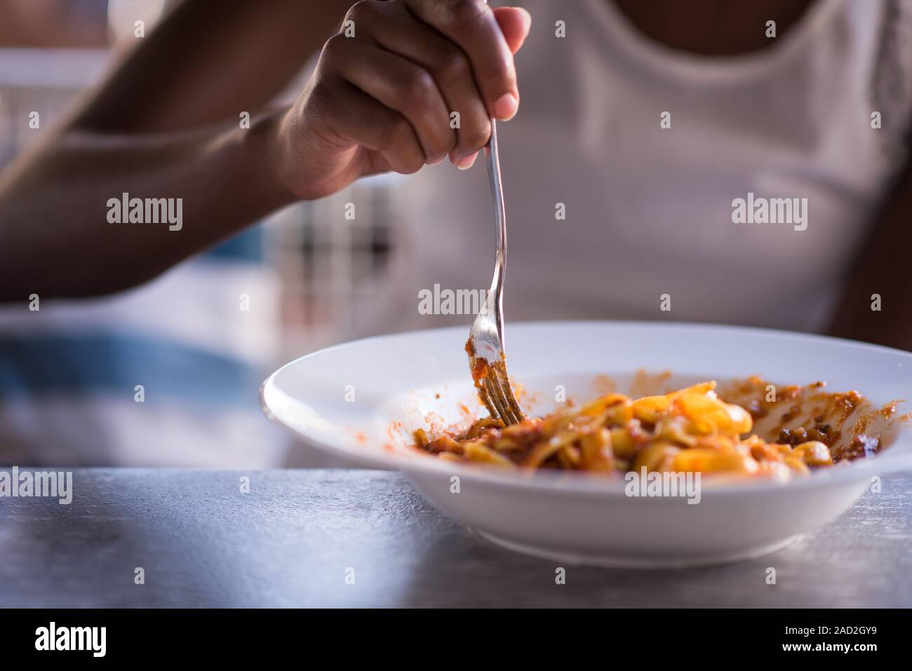 a young African American woman eating pasta Stock Photo - Alamy