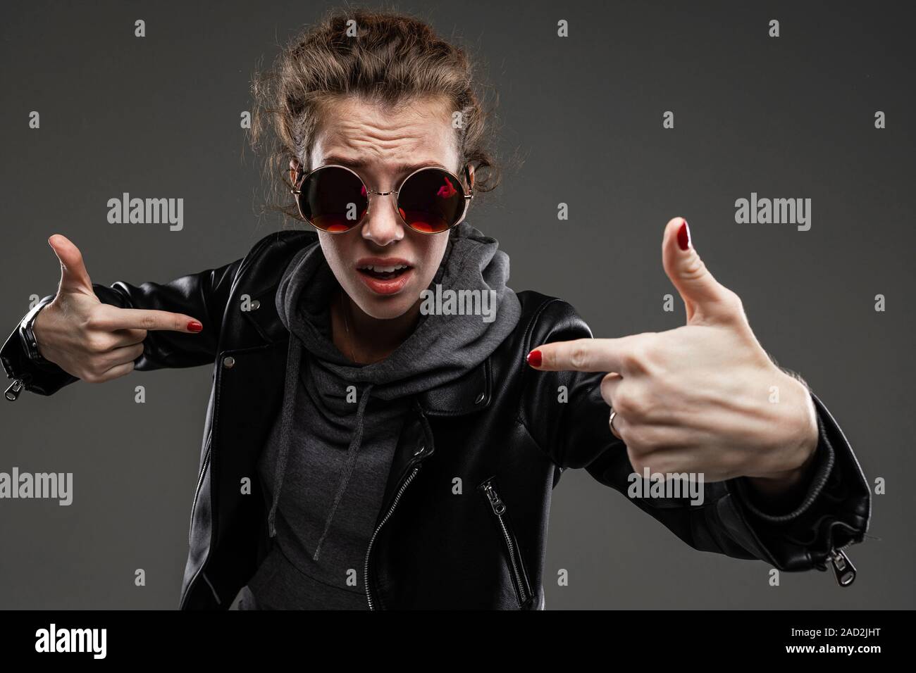 Brutal caucasian girl with rough facial features in a black jacket ...