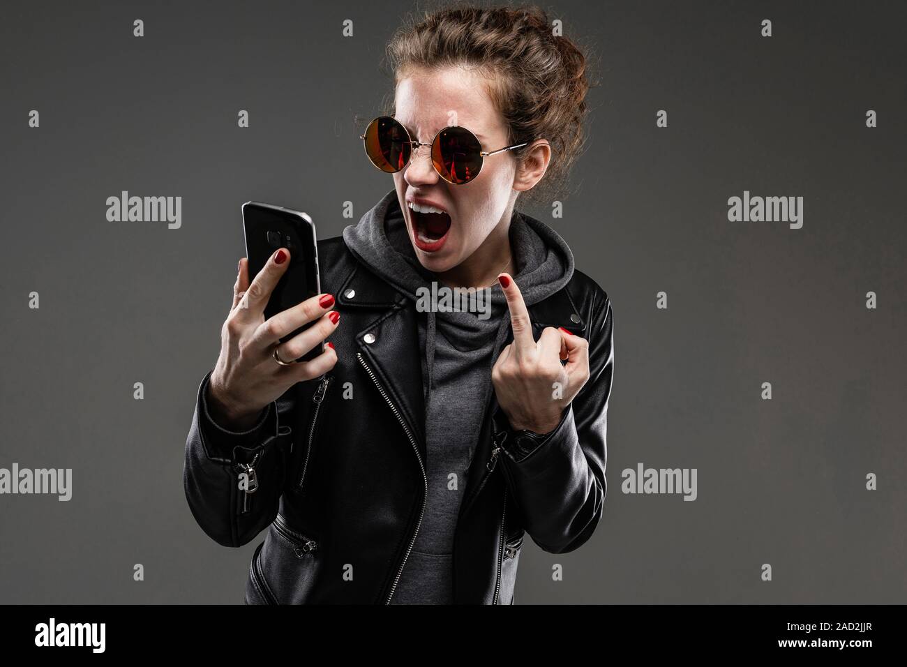 Stubborn caucasian girl with rough facial features in a black jacket ...