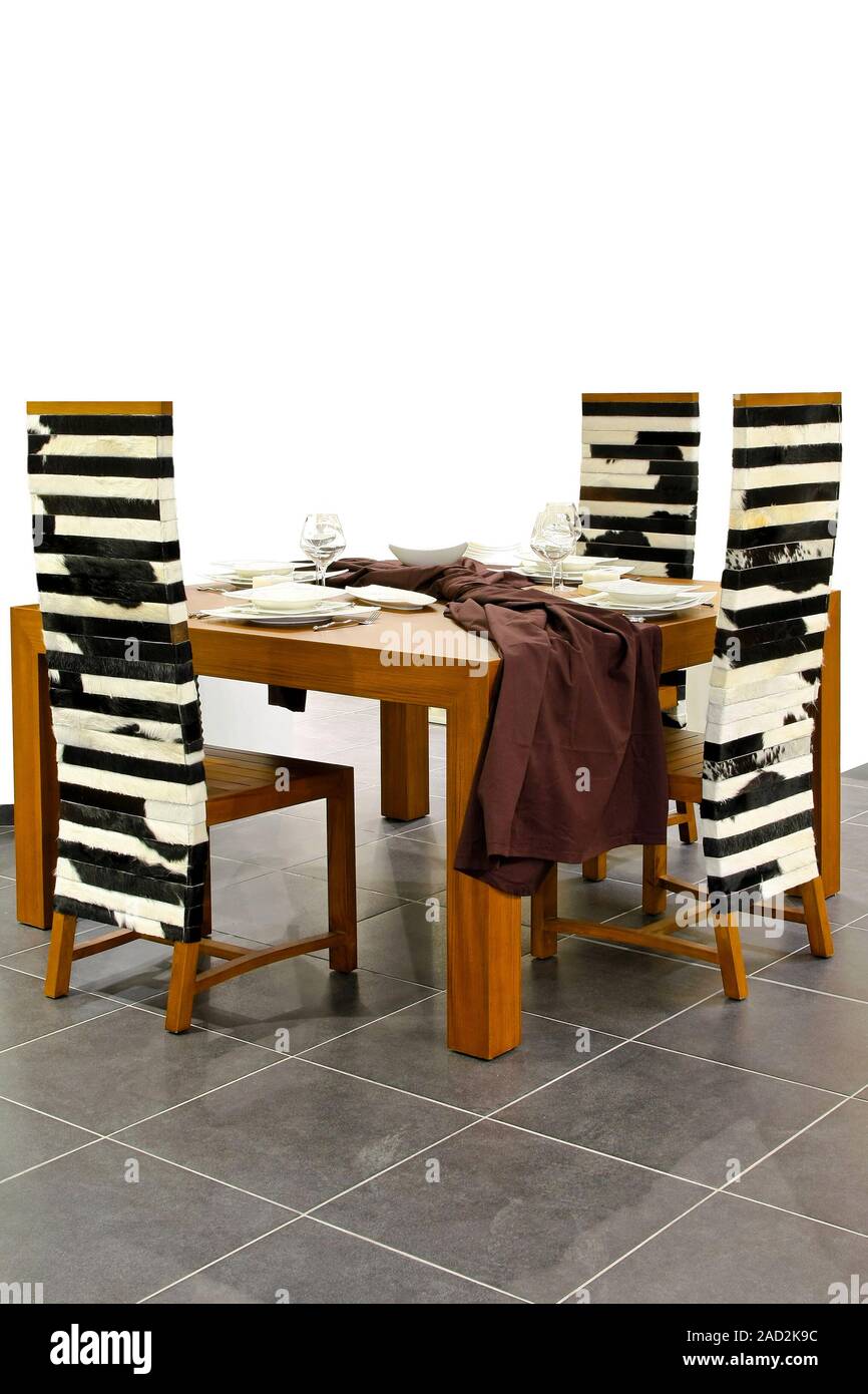 Dining room with wooden table and safari chairs Stock Photo - Alamy