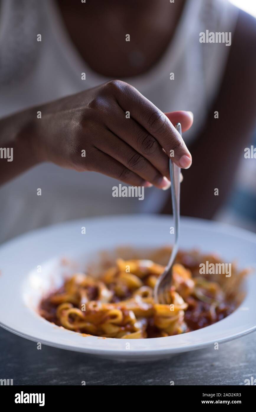 a young African American woman eating pasta Stock Photo - Alamy