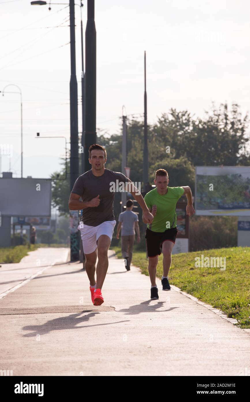 Two young men jogging through the city Stock Photo - Alamy