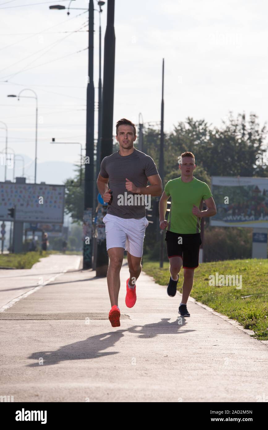 Two young men jogging through the city Stock Photo - Alamy