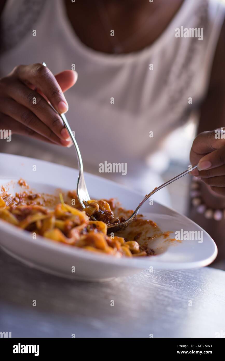 a young African American woman eating pasta Stock Photo - Alamy