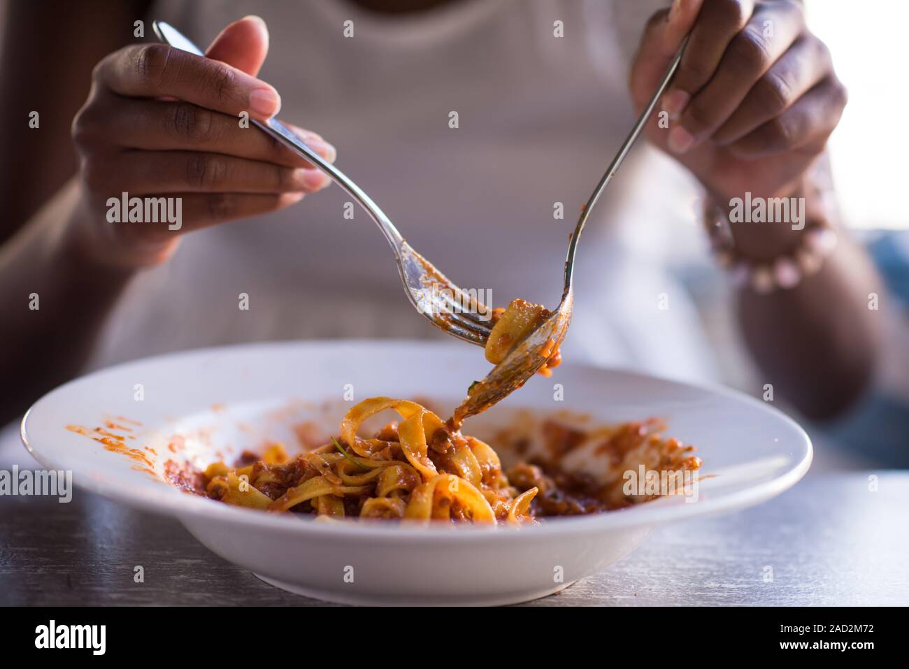 a young African American woman eating pasta Stock Photo - Alamy