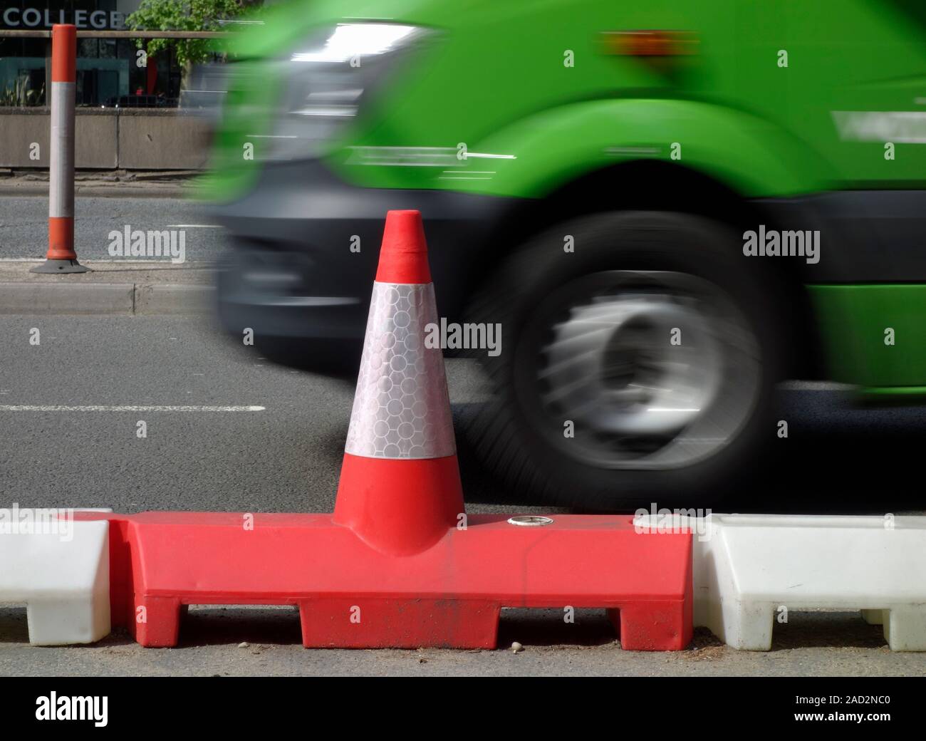 Traffic cone and passing vehicle Stock Photo - Alamy