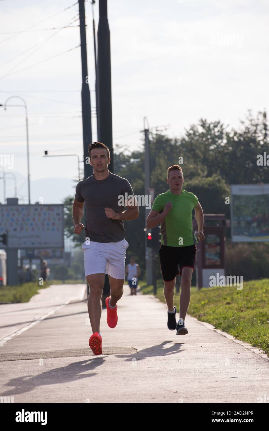 Two young men jogging through the city Stock Photo - Alamy