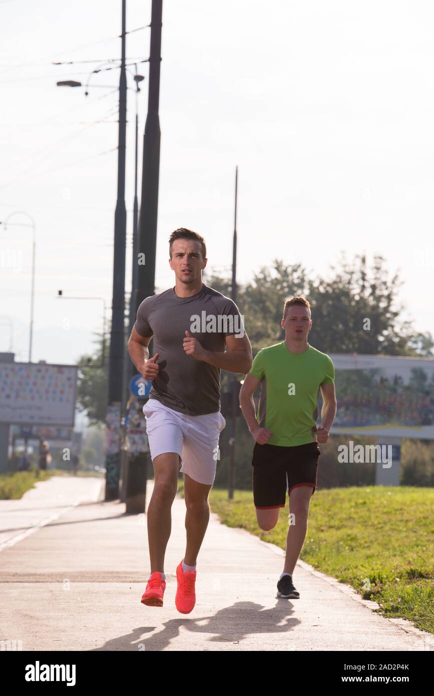 Two young men jogging through the city Stock Photo - Alamy