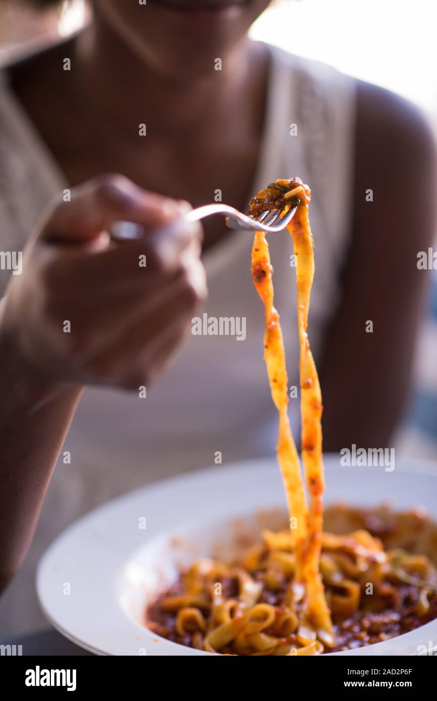 a young African American woman eating pasta Stock Photo - Alamy