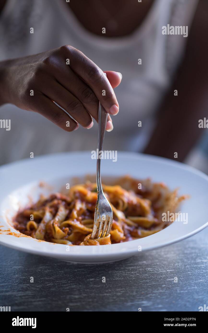 a young African American woman eating pasta Stock Photo - Alamy