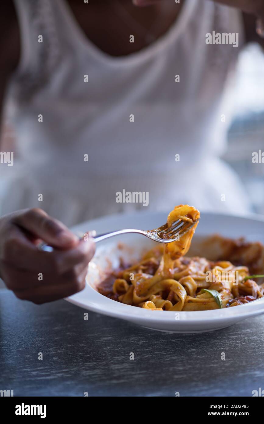 a young African American woman eating pasta Stock Photo - Alamy