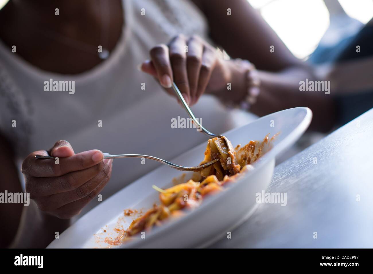 a young African American woman eating pasta Stock Photo - Alamy