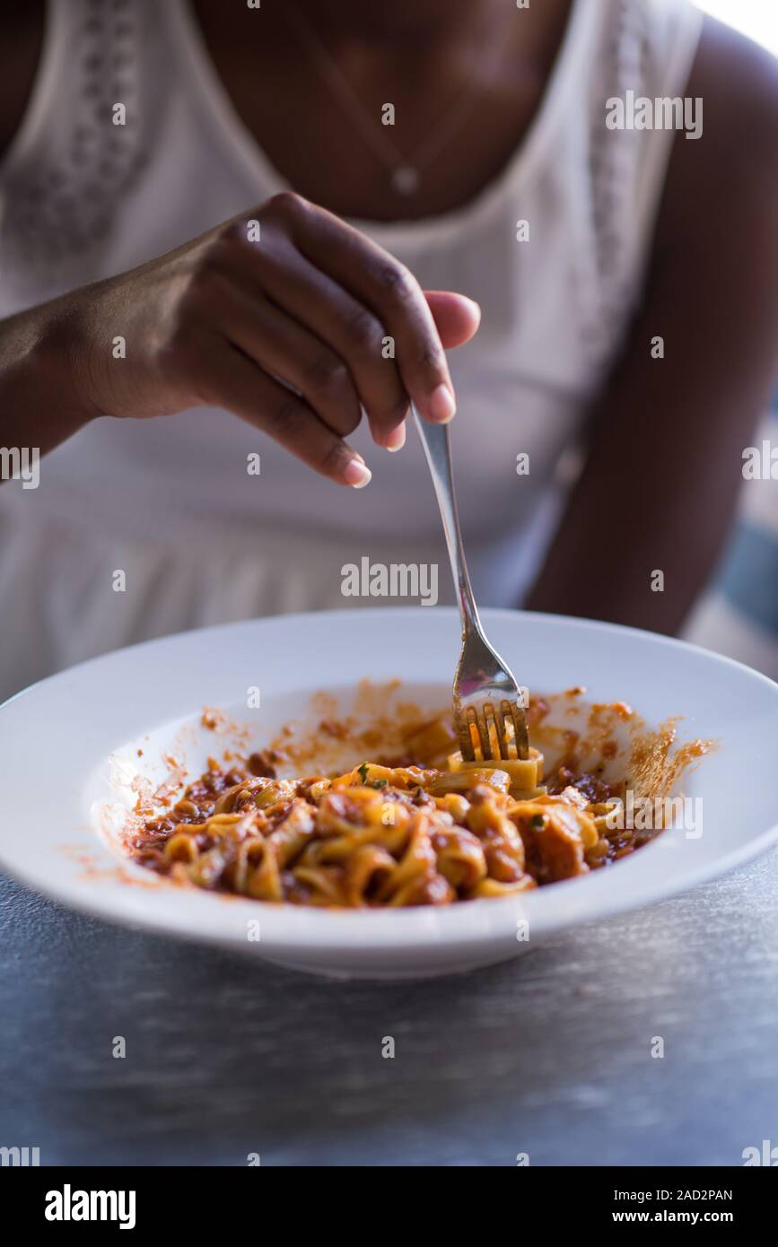 a young African American woman eating pasta Stock Photo - Alamy