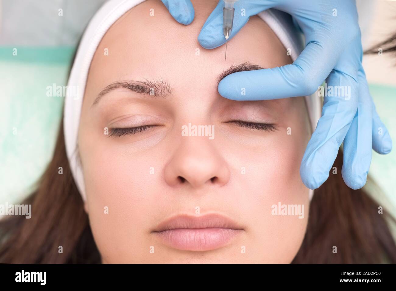 injection into the skin of the face of a young woman, close-up ...