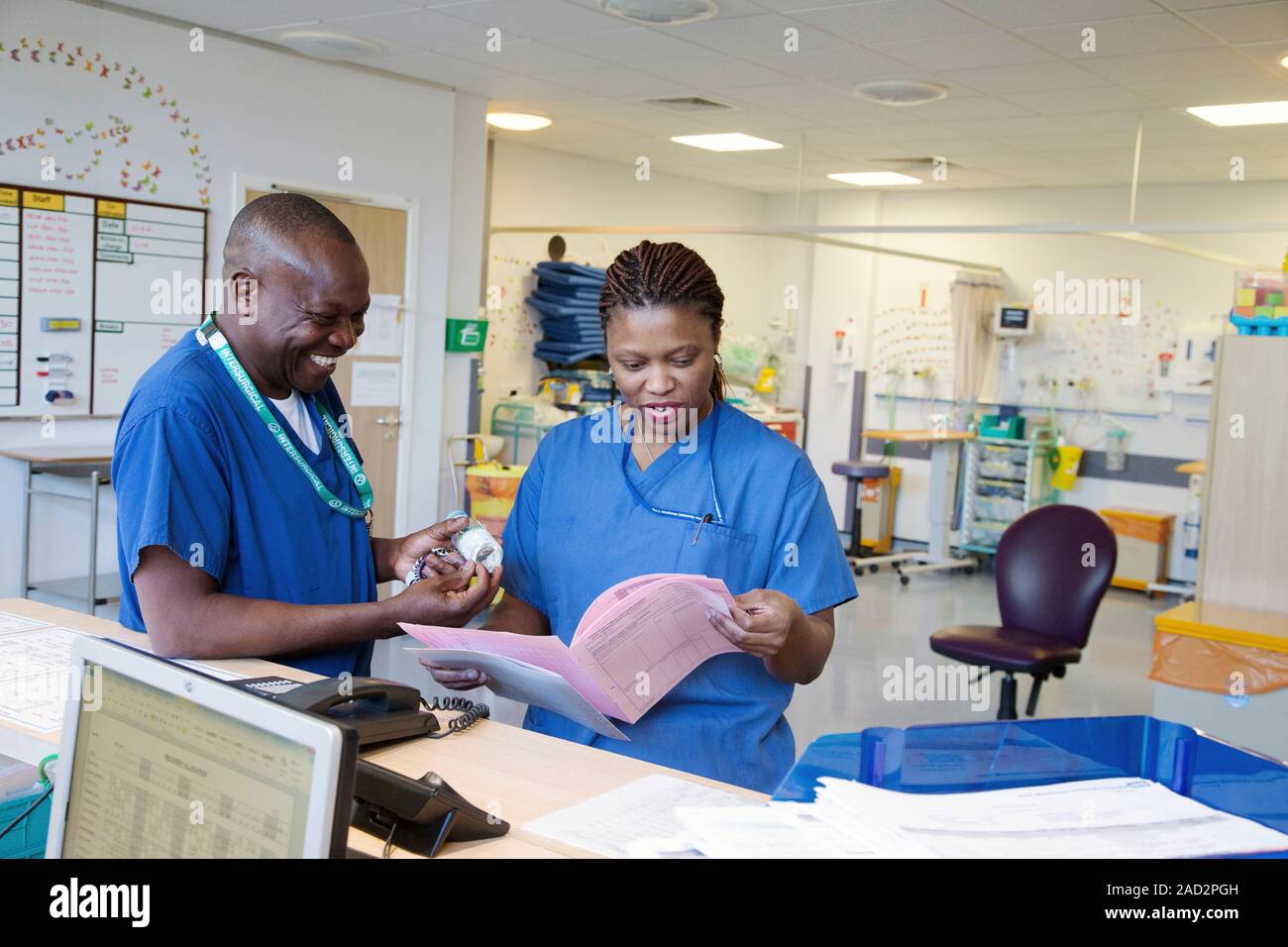 Hospital nurses on a ward, reading patient notes and preparing to ...