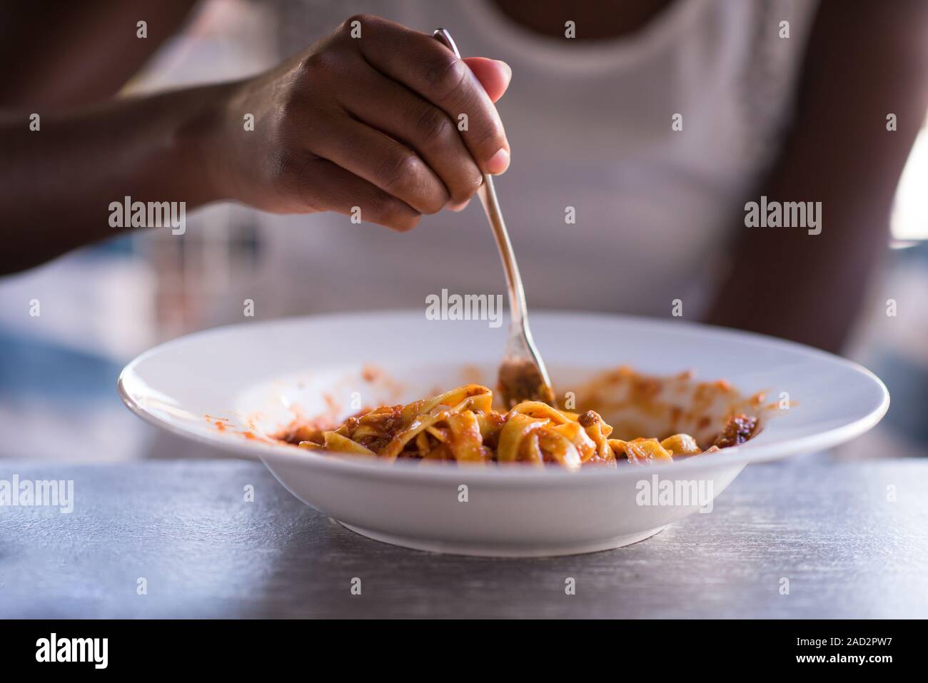 a young African American woman eating pasta Stock Photo - Alamy