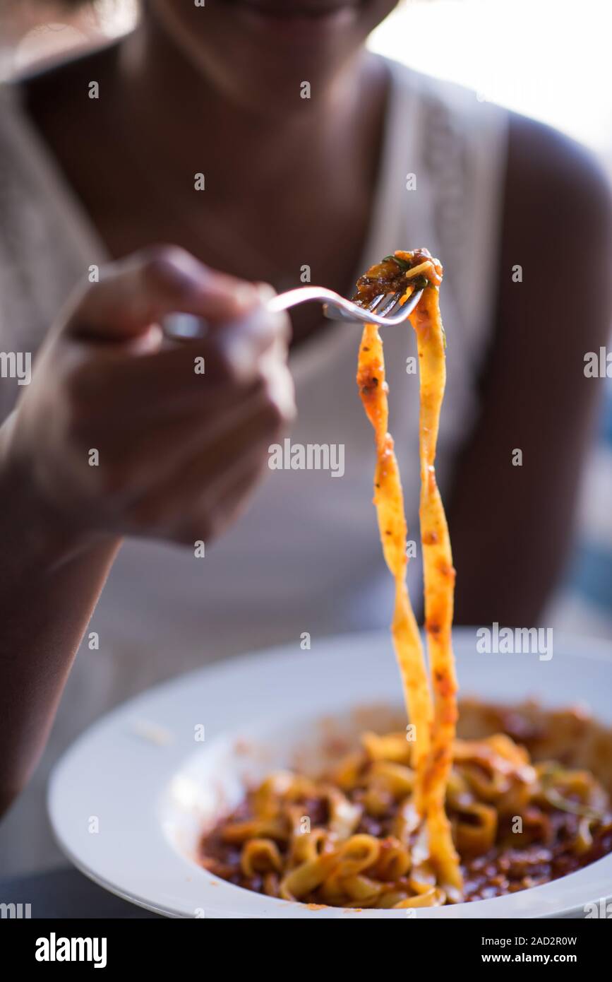 a young African American woman eating pasta Stock Photo - Alamy