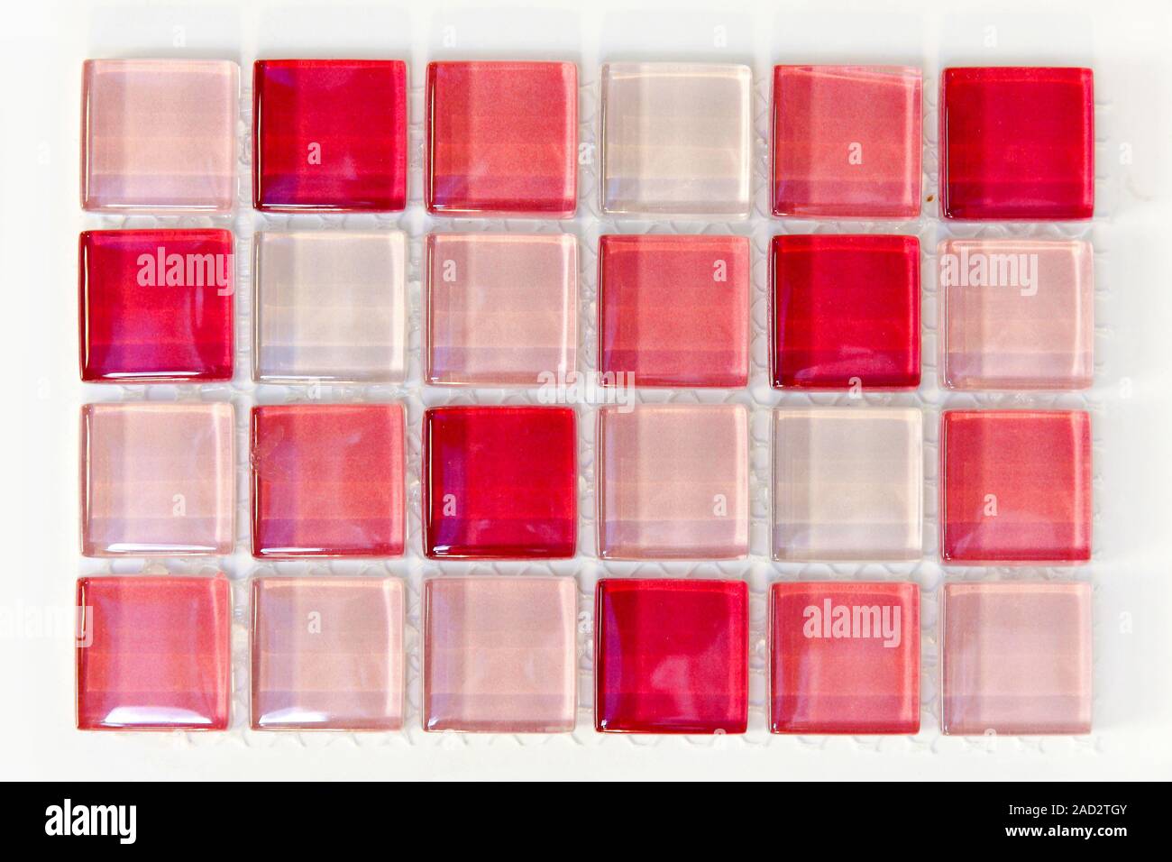 Small glass square tiles in pink colors Stock Photo - Alamy