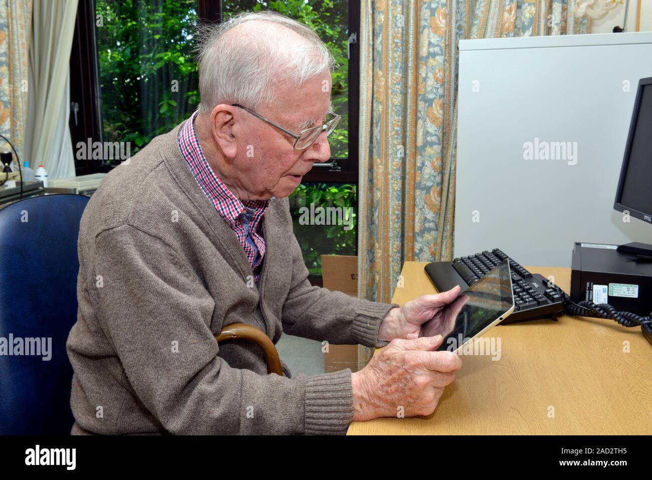 Older man doing a memory test. 91-year-old man using a tablet computer ...